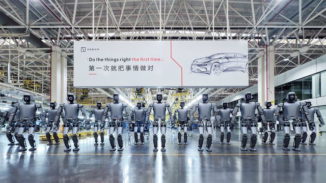 Una fábrica de coches solo con robots humanoides trabajando en equipo ...